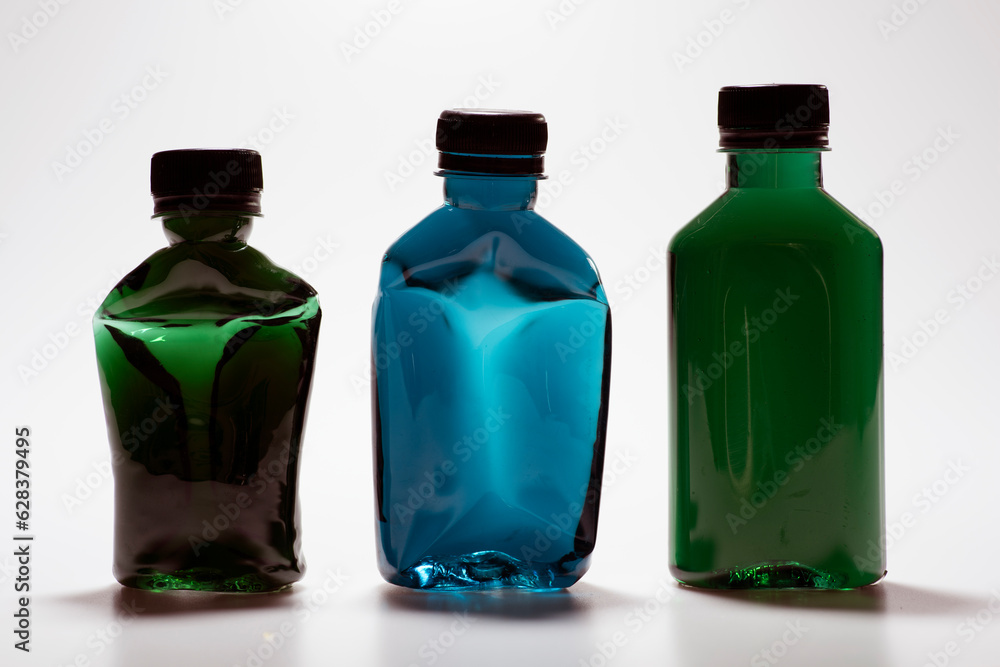 Plastic bottle containers with food colouring dripping in to liquid and ...