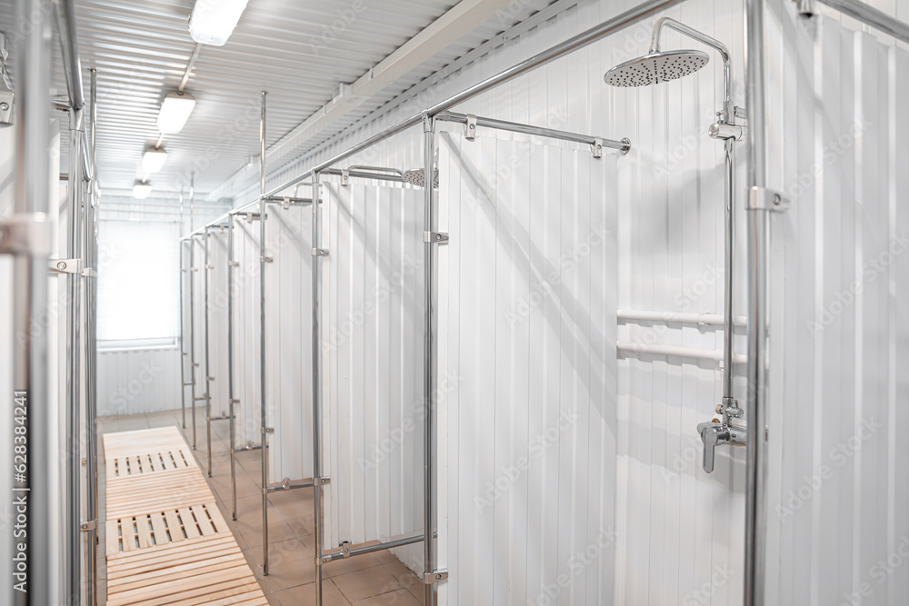 Public shower. Public showers room with several showers. Big, light, empty public shower room ...