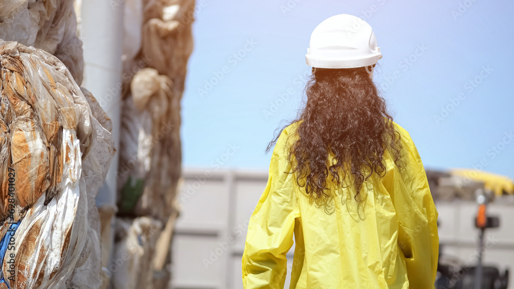 Black-haired inspector explores piles of trash at waste sorting plant ...
