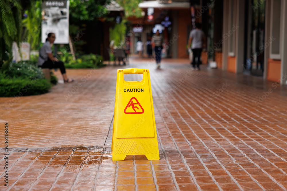 wet floor sign with water drops on wet stone floor. plastic sign ...