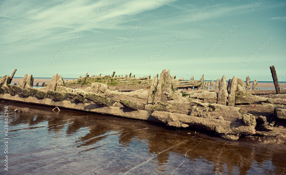 An old historic wooden shipwreck vessel carcass exposed on a desolate ...
