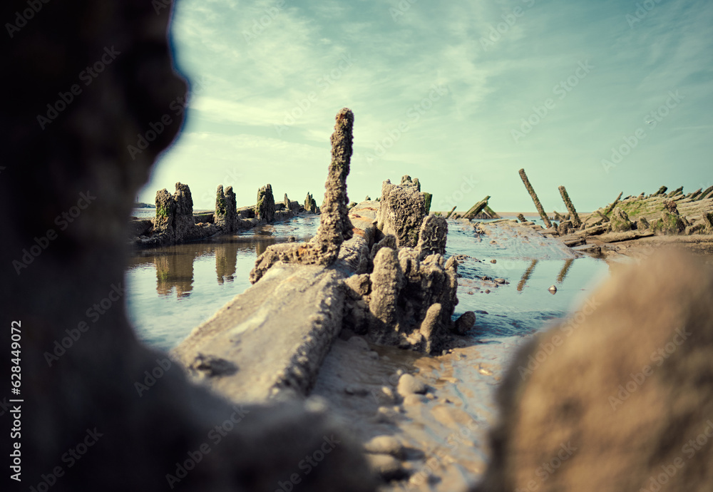 An old historic wooden shipwreck vessel carcass exposed on a desolate ...