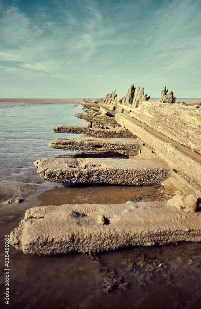 An old historic wooden shipwreck vessel carcass exposed on a desolate ...