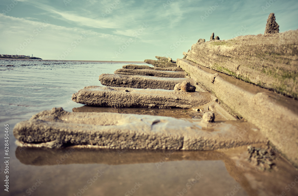 An old historic wooden shipwreck vessel carcass exposed on a desolate ...