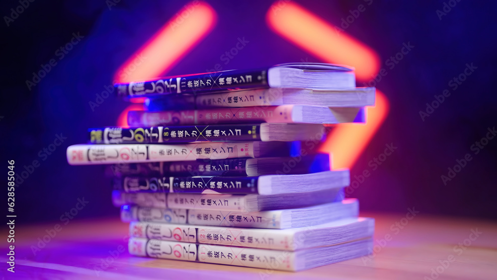 Stacking Japanese manga comic Oshi no Ko on pile surrounded with LED ...