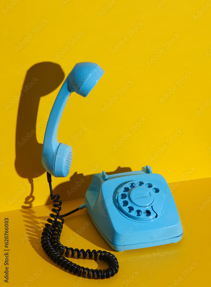 Rotary retro rotary telephone with a floating handset painted in blue ...