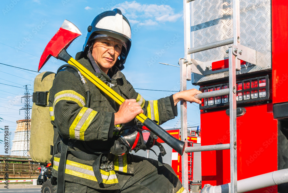 A firefighter in a helmet and breathing apparatus put an assault axe on ...