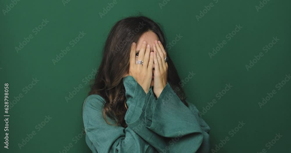 Scared shocked amazed young woman look camera covering hiding face with ...