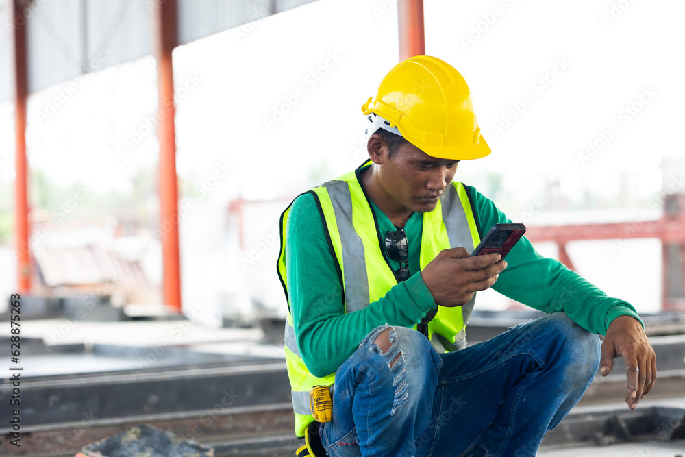 Happy worker enjoying free time and using smartphone. Asian man forman ...