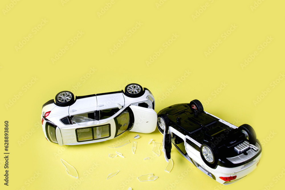 Two mini toy car crash on yellow background, incident, car traffic ...