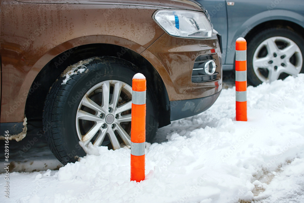 Car bumper and plastic warning post closeup. Car parked close to ...