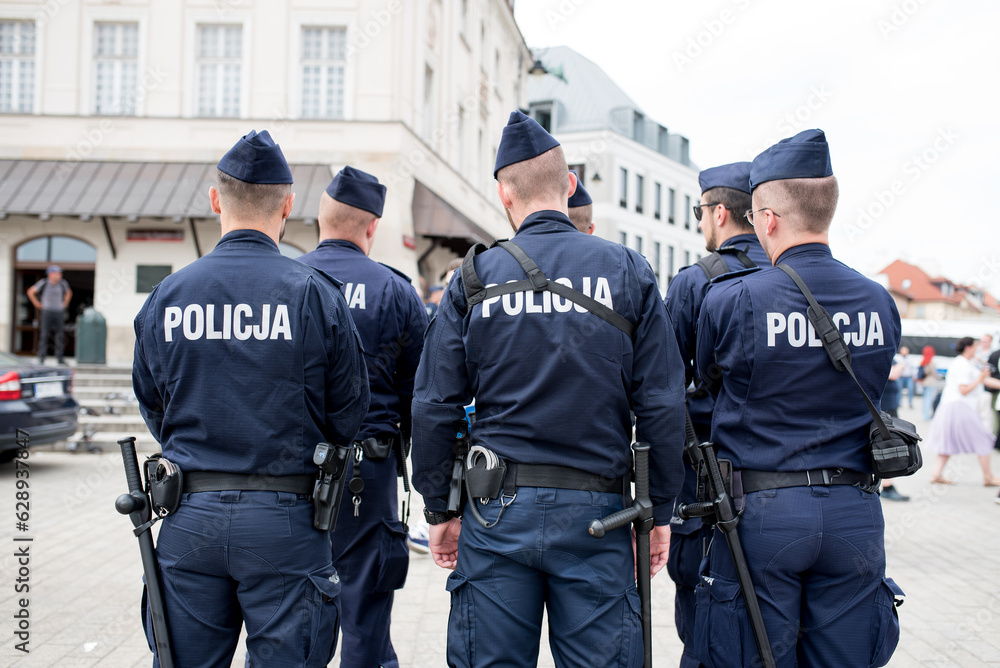 Polish policemen stand with their backs to the camera. Stock Photo ...