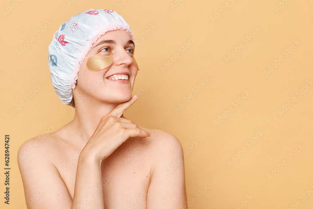 Attractive smiling woman wearing shower cap standing isolated over ...