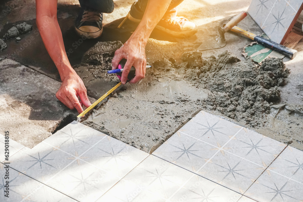 Process of floor tiles installation.Hand of workers using tape measure ...