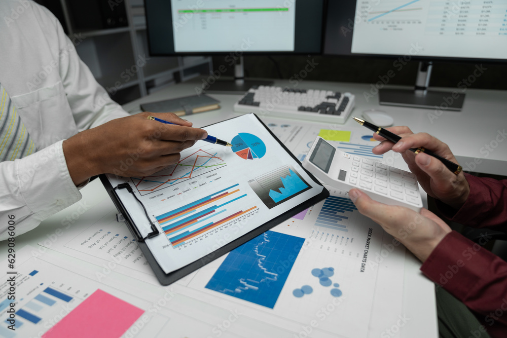 Team of business people working together in a conference room, planning, analyzing Calculating ...