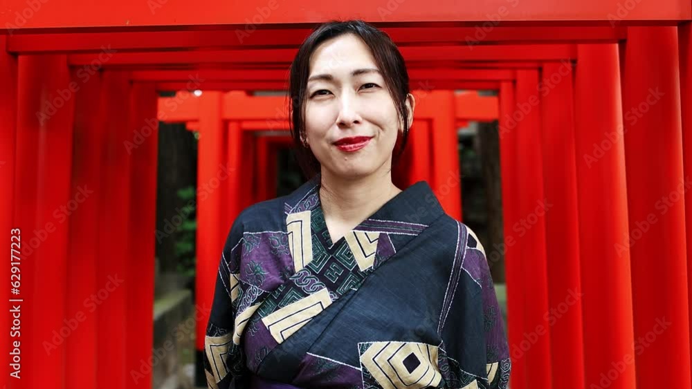 beautiful Japanese woman in a kimono in a torii gate tunnel in a ...