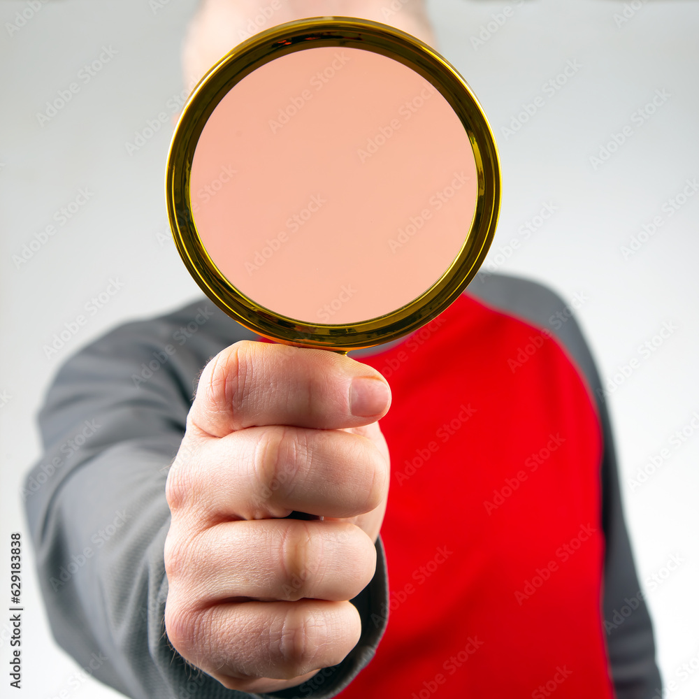 man hides his face with a magnifying glass. The concept of searching ...