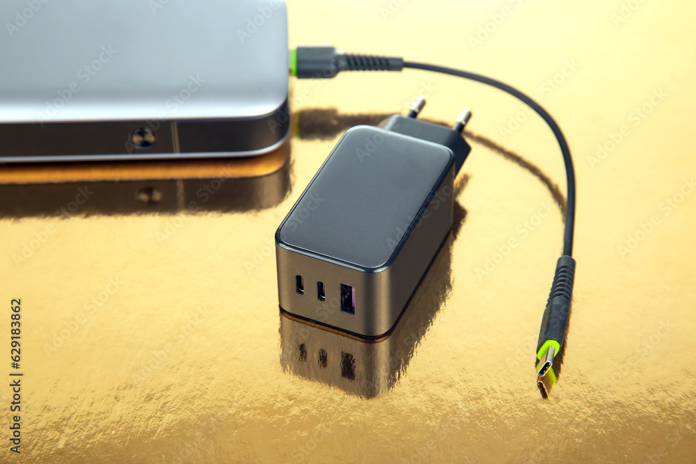 Power bank and charging plug with cable on a golden background ...