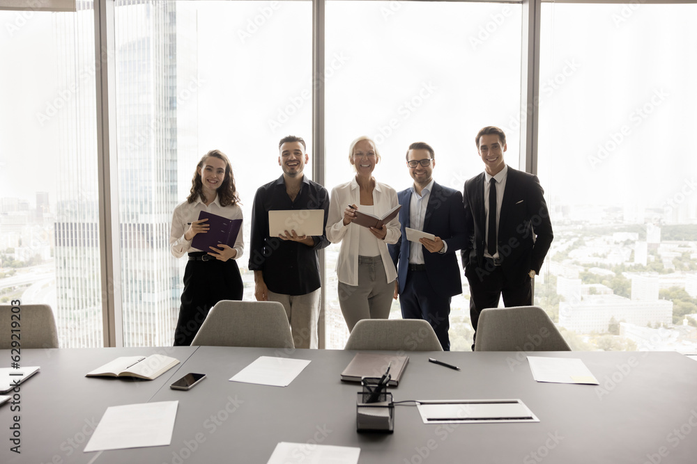 Business team of happy younger and older employees standing in row in ...
