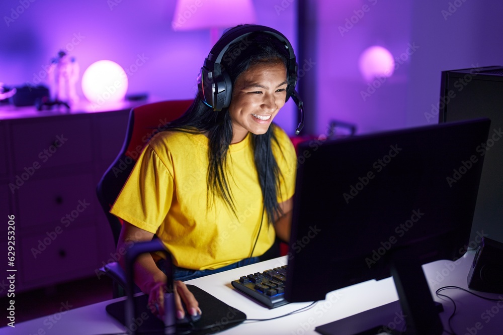 Young beautiful latin woman streamer playing video game using computer ...