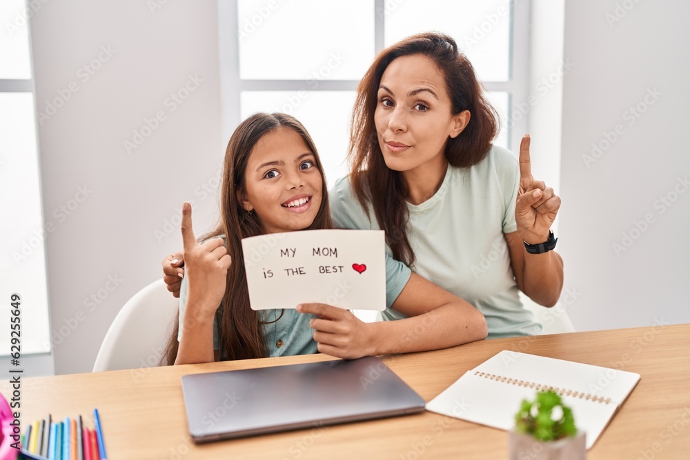 Young mother and daughter holding my mom is the best smiling with an ...