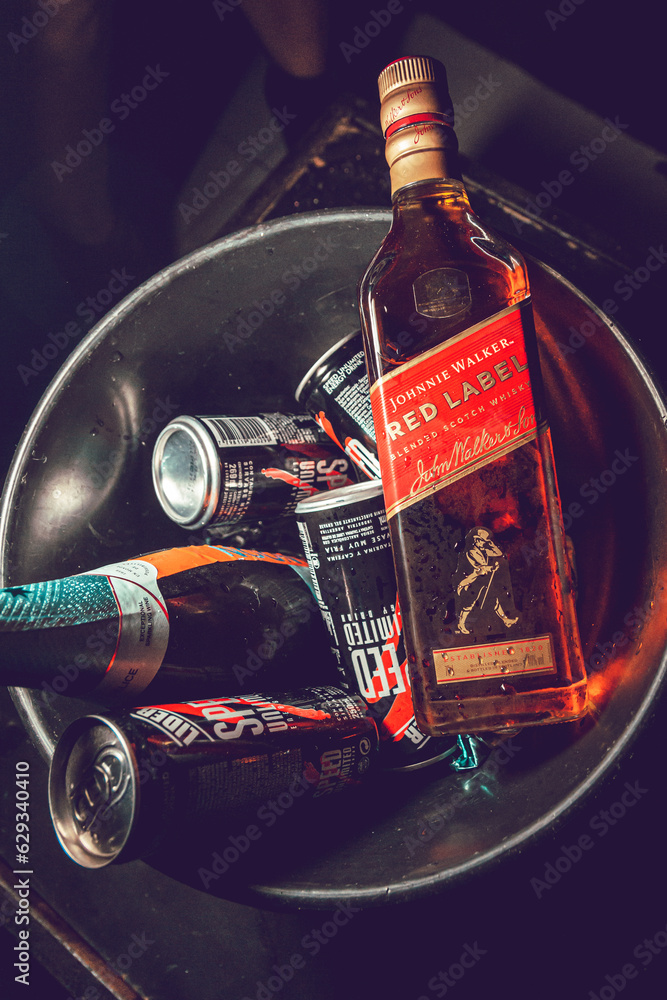 Bottle of Johnnie Walker Red Label whisky and cans of energy drinks ...