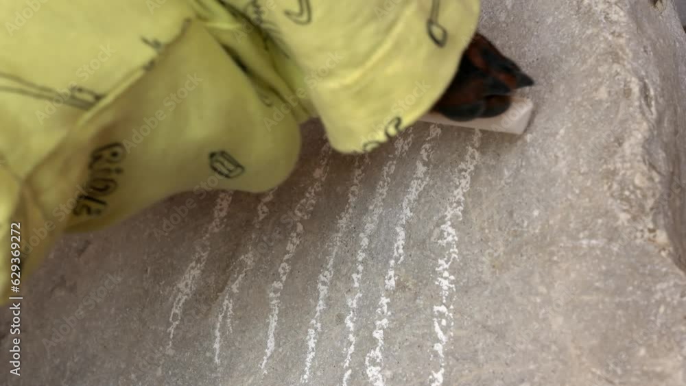 Dog paw crosses out seven white lines drawn in chalk on stone ...