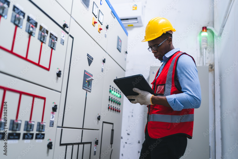 Professional engineering of modern factory checking to automatic machinery. Black worker with ...