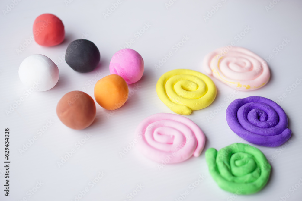 Colorful plasticine were sculpted into different shapes, balls and ...