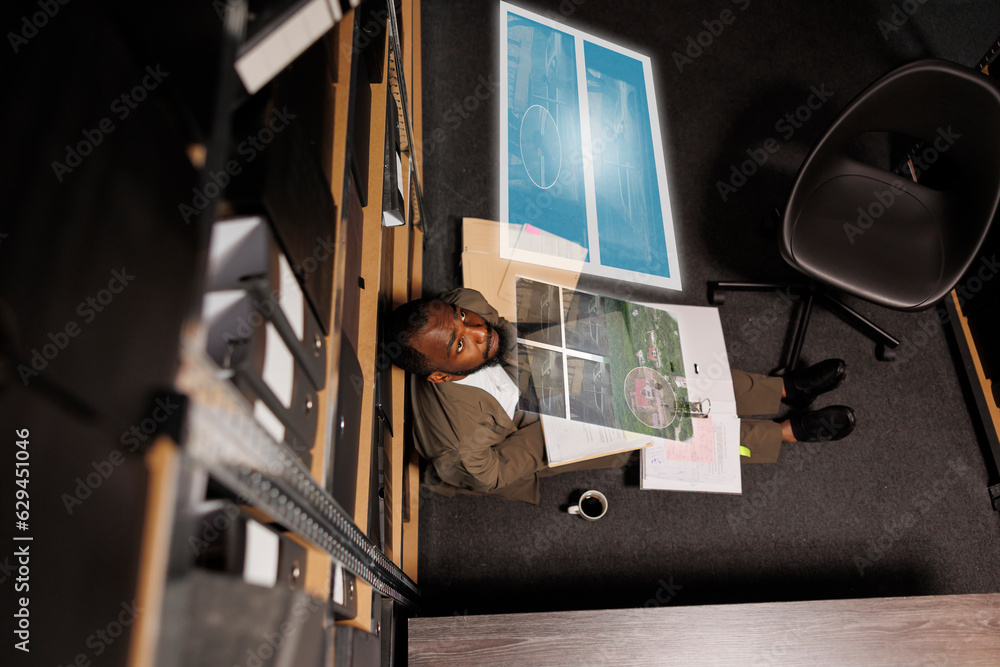 African american man examining augmented reality clues, checking ...