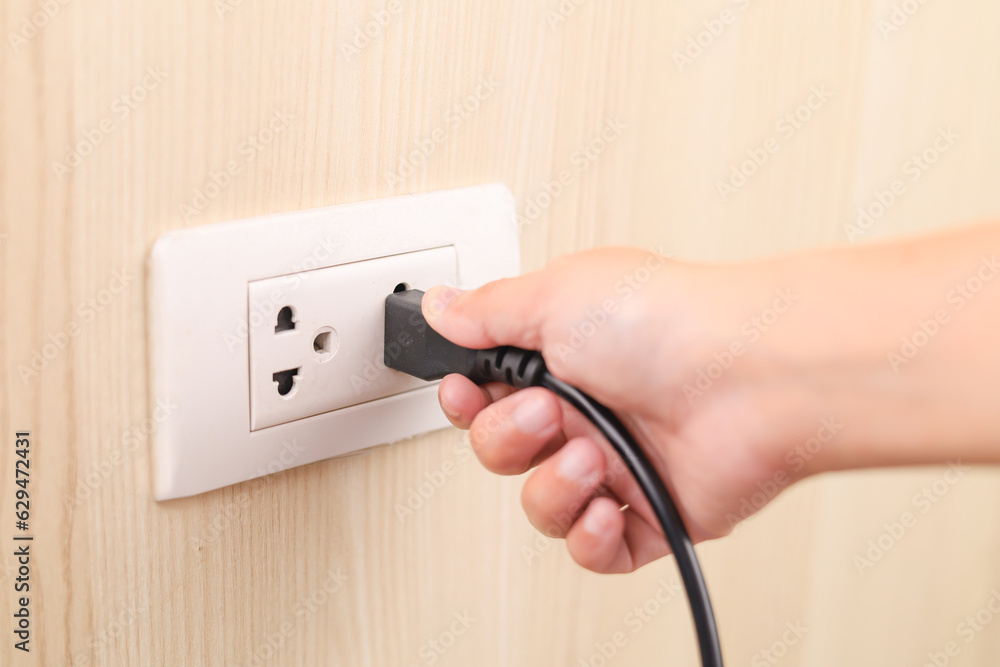 Close-up woman's hands are Unplugged or plugged in power outlet ...