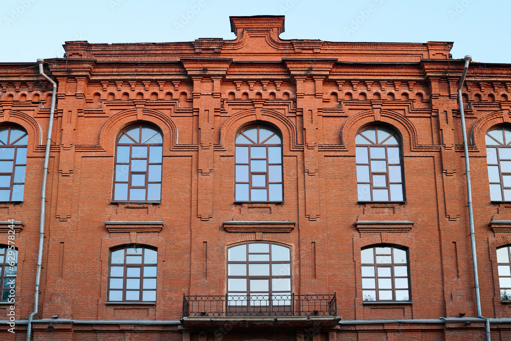 Upper part of old historical red brick building with group of windows ...
