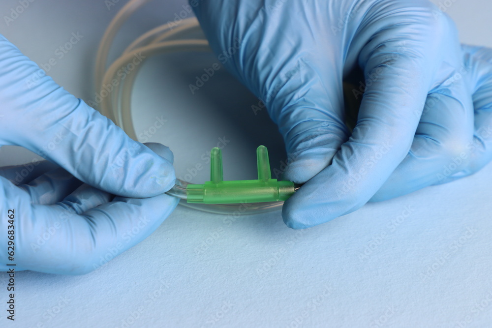 Oxygen cannula beeing hold by a healthcare professional wearing gloves ...