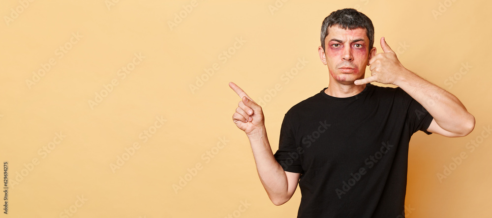 Sad sufferer man in black T-shirt with bruises and abrasions on his ...