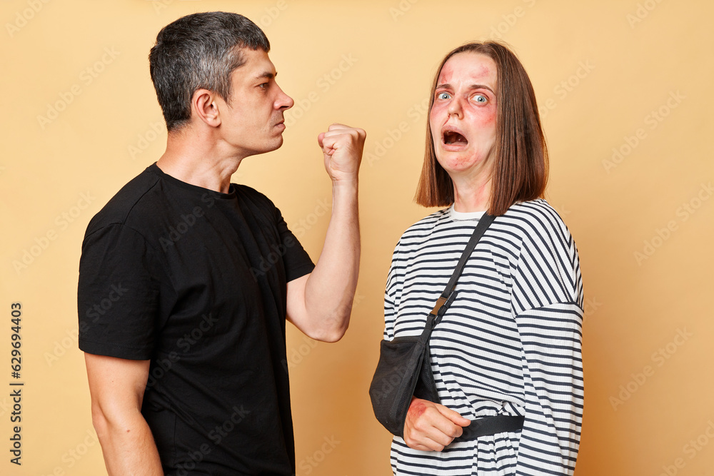 Strict bossy angry man showing fist to woman with bruise isolated over ...