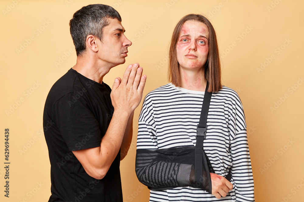 Apologetic man and offended despair woman with bruise isolated over ...