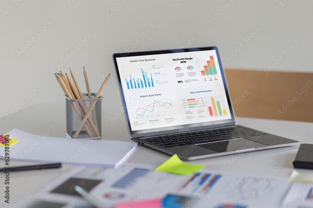 Laptop Computer finance graph, notebook, and eyeglasses sitting on a ...