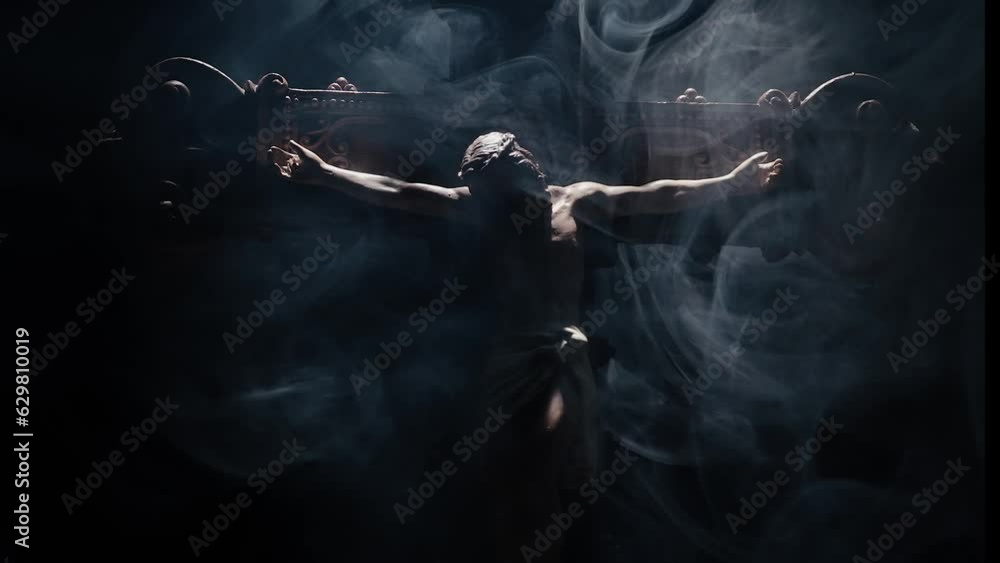 Jesus Christ on a dark wooden cross with smoke on black background ...