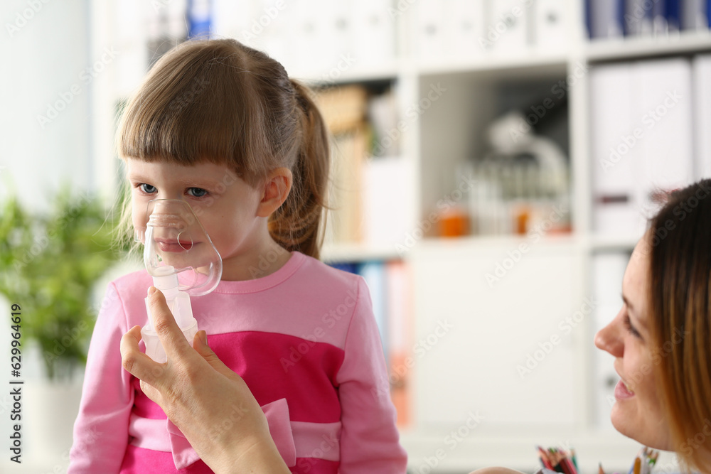 Little girl child holds mask vapor inhaler and treats asthma breathing ...