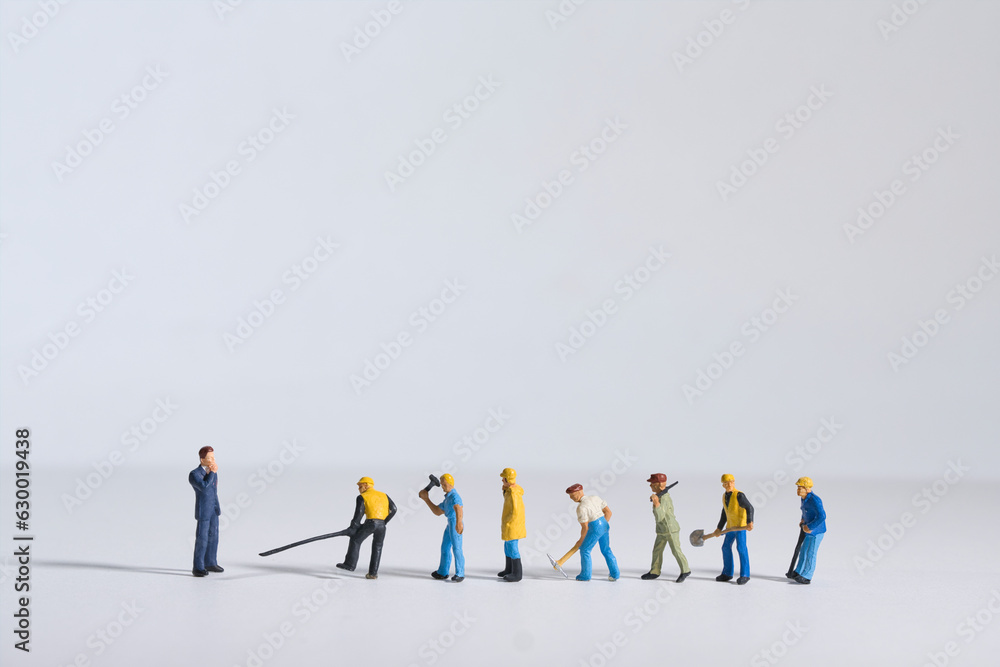 Workers from different professions stand in line in front of an ...