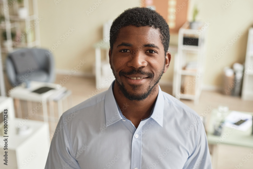 Front view closeup portrait of smiling black man standing in office and ...