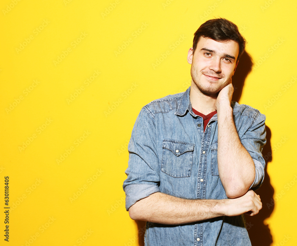 Smiling Handsome Male Model In A Denim Jacket On A Yellow Background