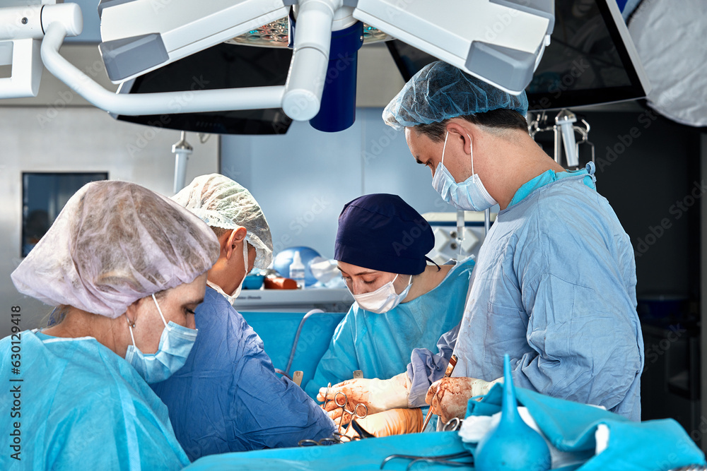 Surgeons team during complex surgical operation in a sterile operating ...