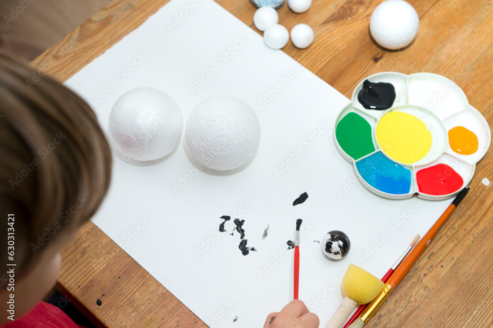 Boy painting styrofoam balls when making model of Solar System for ...