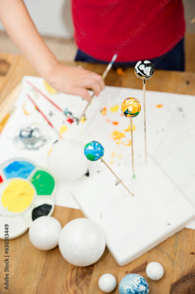 Boy painting styrofoam balls when making model of Solar System for ...
