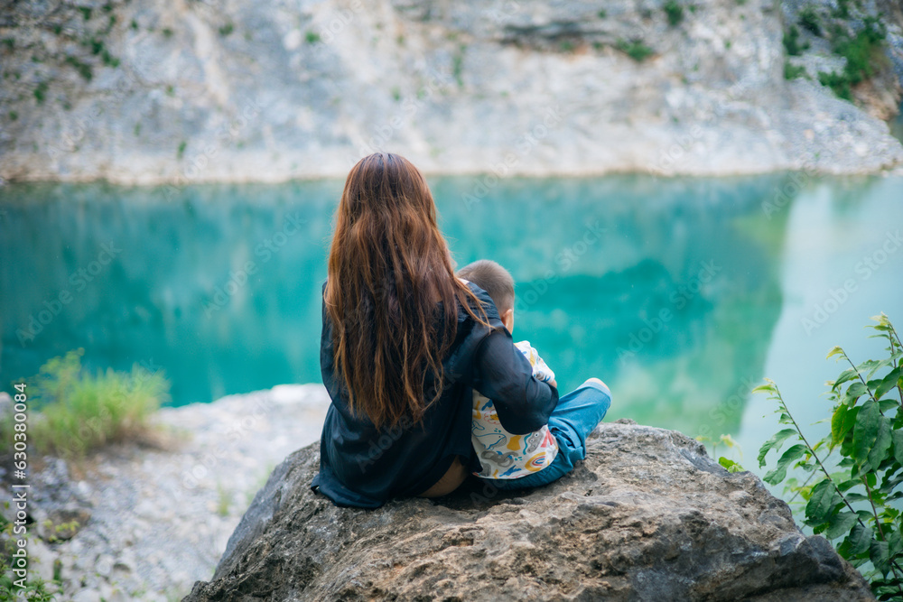 Mother and son sit back and look at the natural scenery. rocky ...