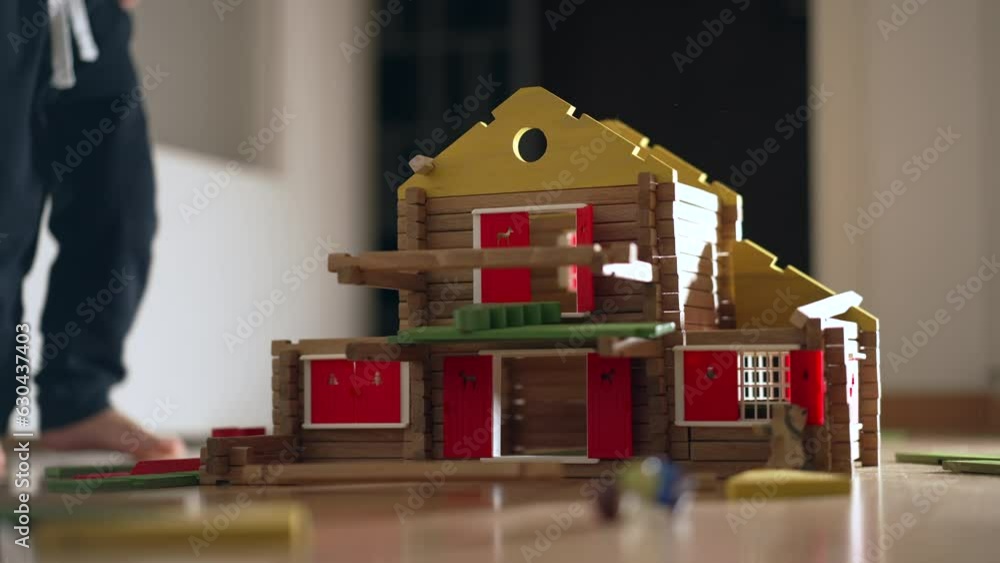 Child destroying house construction miniature. Kid kicking model wood ...