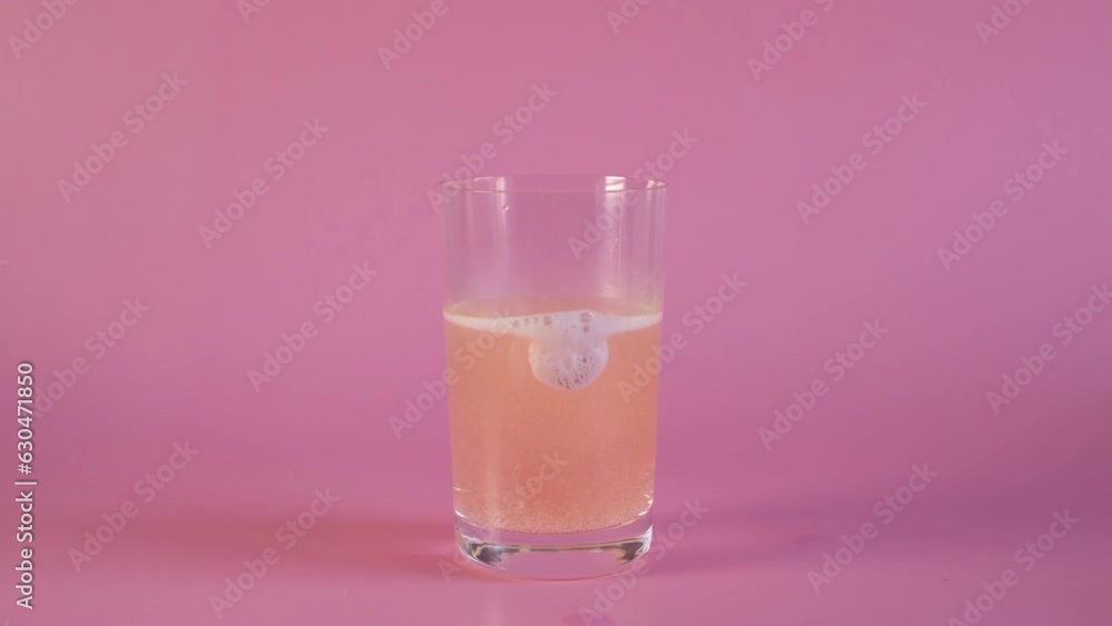 Glass of water on pink background. Effervescent vitamin C tablet ...