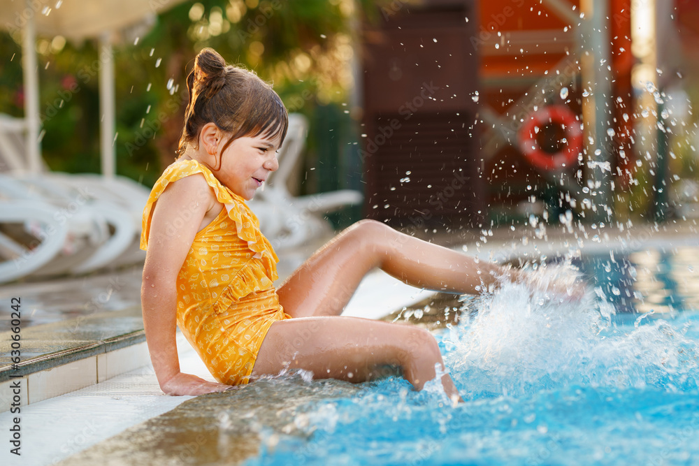 Little preschool girl playing in outdoor swimming pool by sunset. Child ...
