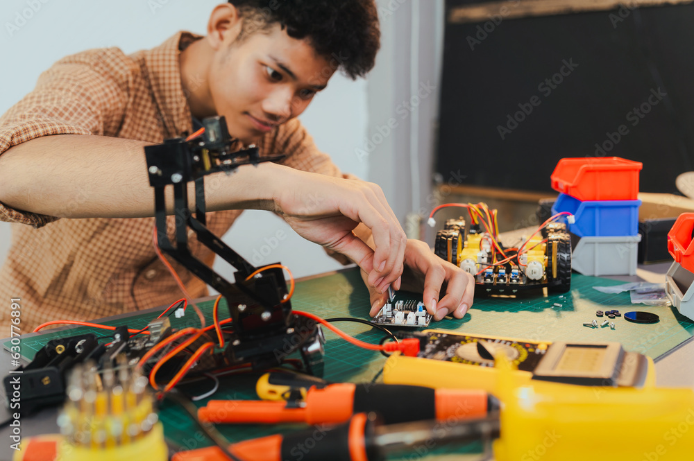 Foto de Asian young man assembling a robotic car, focus on robotics ...